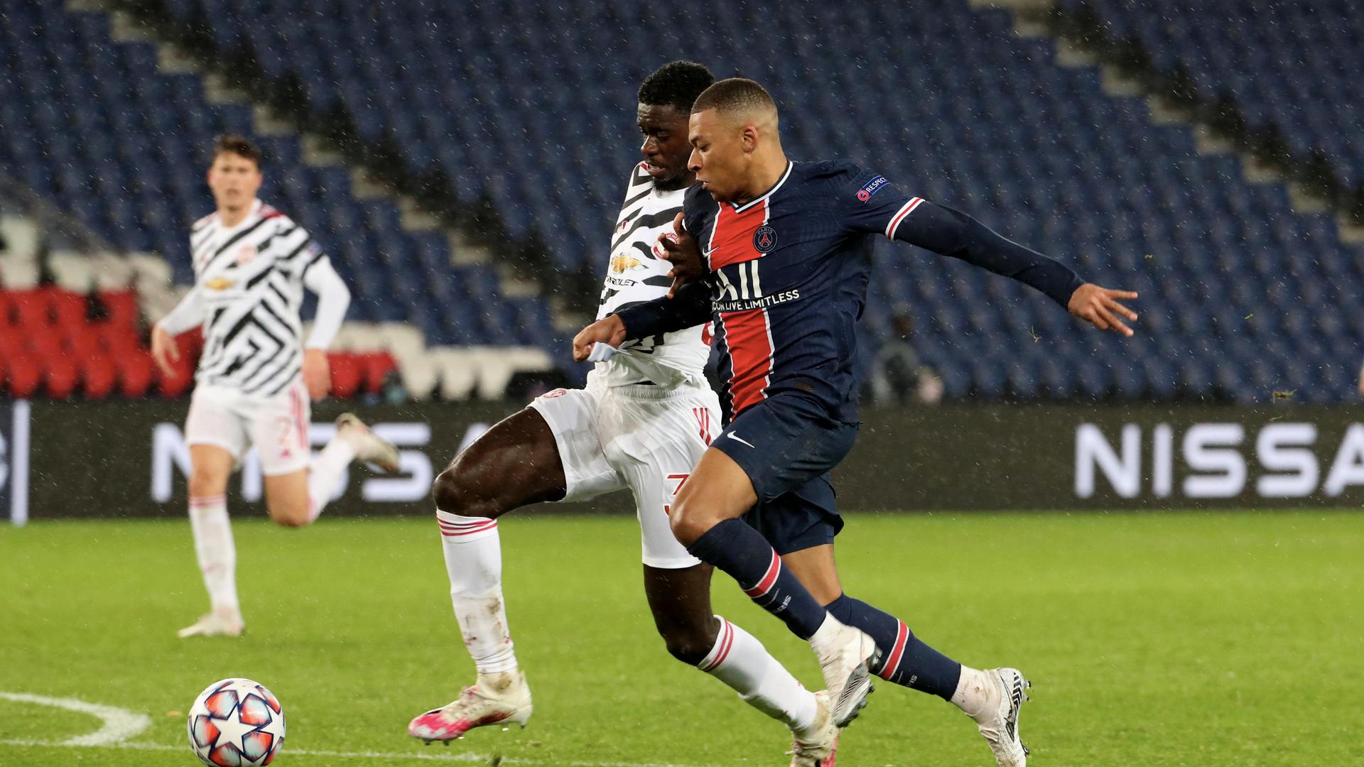 PSG forward Kylian Mbappe tackled by Tuanzebe and Wan Bissaka ...